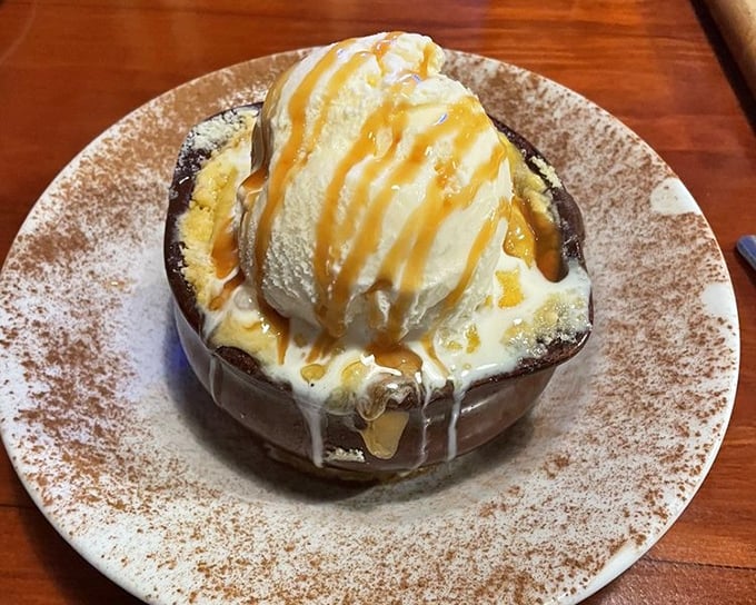 A warm apple cobbler crowned with vanilla ice cream and caramel drizzle—proof that even steakhouses understand the importance of a sweet finale.