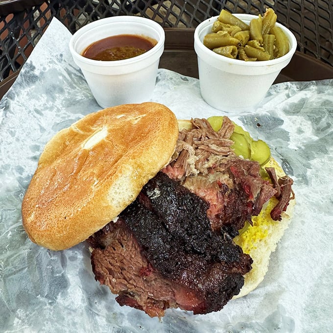 The barbecue sandwich in its final form—bark-crusted brisket with pickles for tang and a bun that knows its supporting role.
