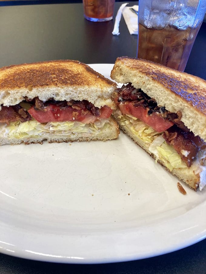 The BLT elevated to art form—crispy bacon, garden-fresh tomato, and lettuce on perfectly toasted bread, cut to reveal its glorious layers.