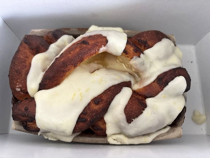 The babka doesn't just have swirls—it has personality, with cream cheese frosting draped like a couture gown over its cinnamon-scented curves.