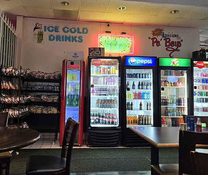 The beverage wall glows with promise—a rainbow of sodas, beers, and Louisiana favorites that wash down spicy Cajun fare with refreshing precision.