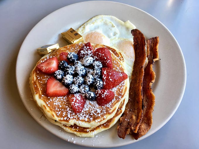 Pancakes that deserve their own Instagram account – fluffy discs of joy topped with berries, powdered sugar, and served with bacon that's achieved perfect crispness.