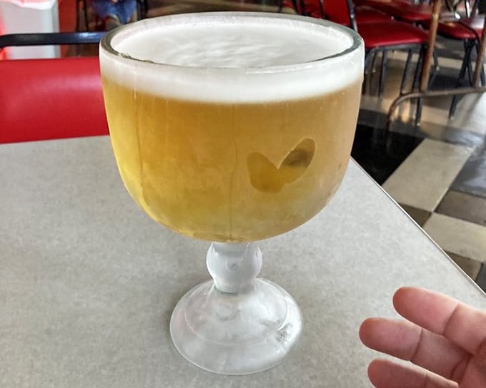That's not just a beer—it's a goblet of golden happiness served in a glass so frosty it practically requires mittens.