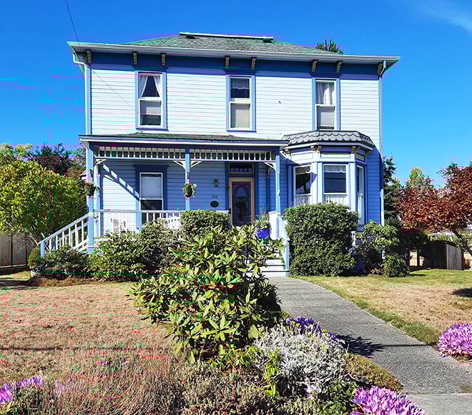 The blue Victorian home with its perfect garden isn't showing off – it's just living its best life while making the rest of us question our landscaping choices.