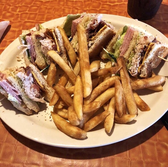 The club sandwich—the architectural marvel of the lunch world—stacked high enough to require those toothpicks and served with fries that look perfectly golden.