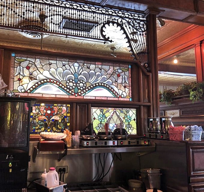 Ornate stained glass backdrops the coffee station – even the practical elements here are framed by unexpected beauty.