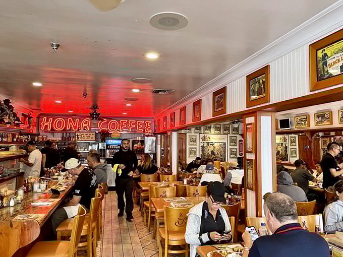 The bustling counter beneath the glow of "KONA COFFEE" neon—where locals and visitors alike gather for morning fuel before island adventures.