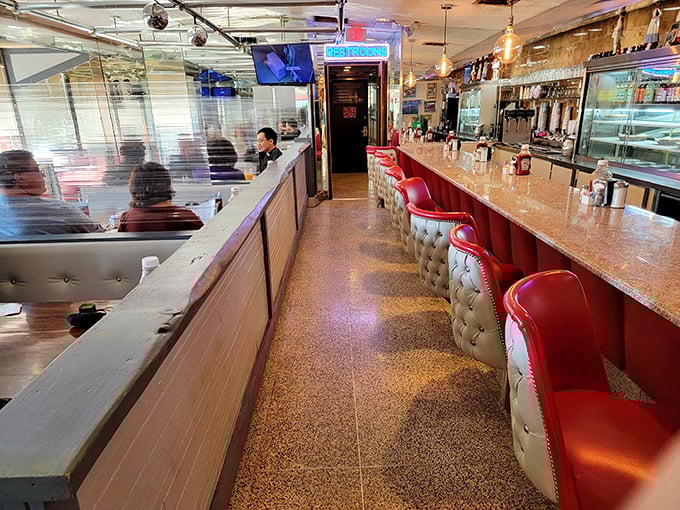 The diner's interior corridor—where the red stools stand like loyal soldiers, ready to support you through thick and thin (mostly thick after eating here).