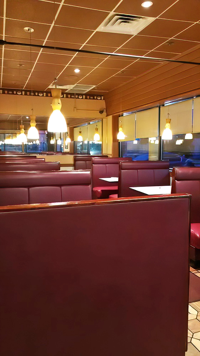 The dining area's warm lighting and booth dividers create little islands of privacy – perfect for intimate conversations or shameless pancake hoarding.
