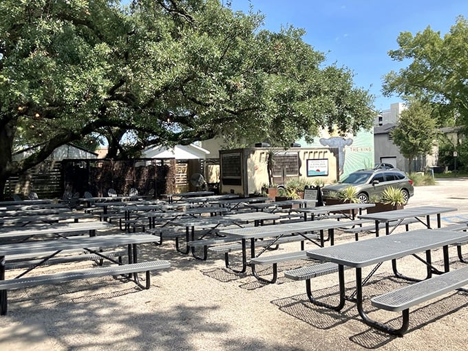 Picnic tables under dappled oak shade—nature's dining room for enjoying meat sweats in the company of fellow barbecue enthusiasts.