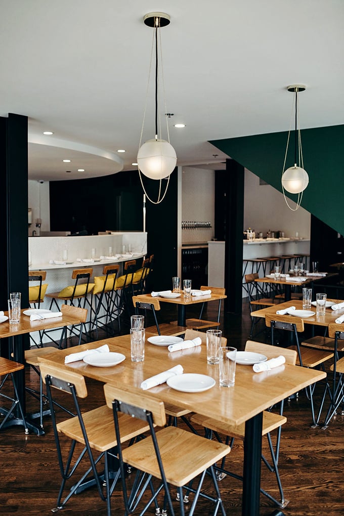 Clean lines, warm wood, and those globe lights create the perfect backdrop for the serious business of enjoying exceptional food.