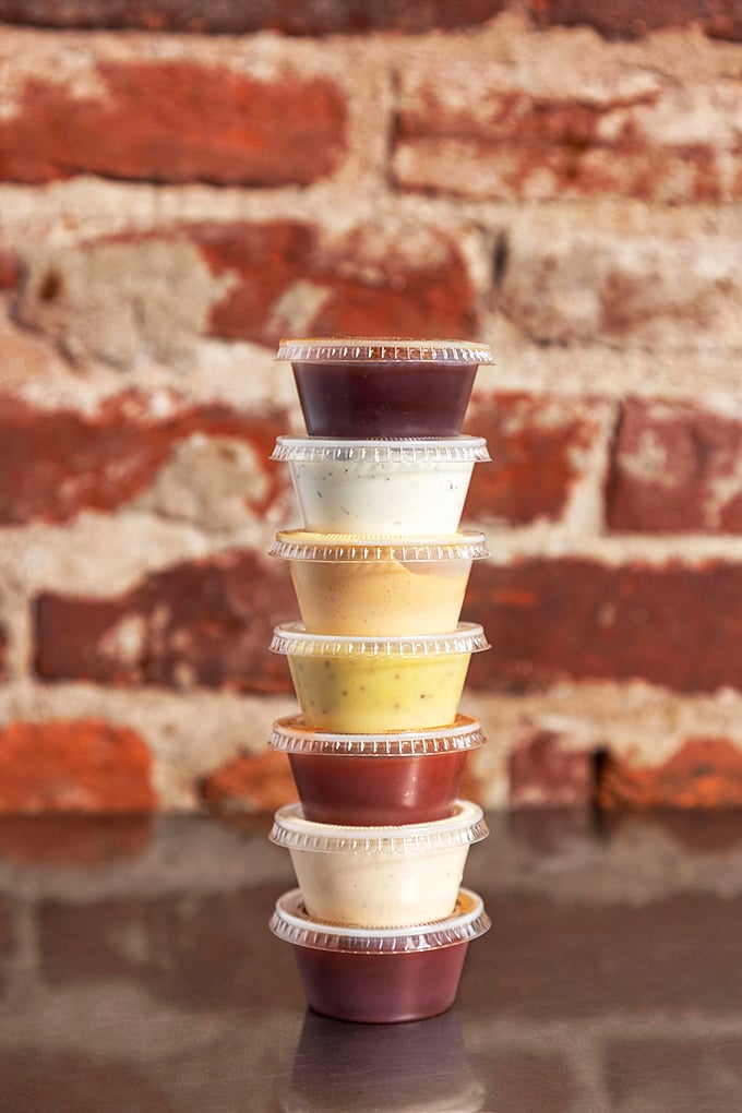 A tower of house-made sauces stands ready for duty—each one a different personality waiting to complement your chicken in its own special way.