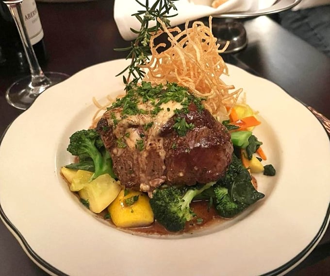 A perfectly cooked filet mignon nestled among vegetables like a king holding court. The sauce isn't just poured—it's carefully composed.