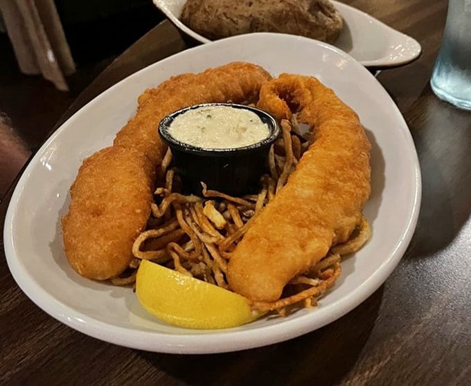 Fish and chips that could make a Londoner homesick. The golden batter shatters with each bite, revealing tender fish beneath—a textural masterpiece.