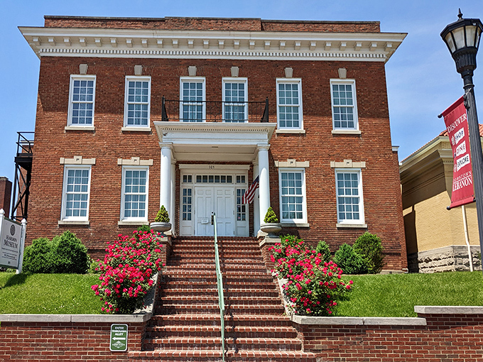 Brick steps and crimson flowers lead to preserved history, where the past is carefully protected and proudly shared with visitors.