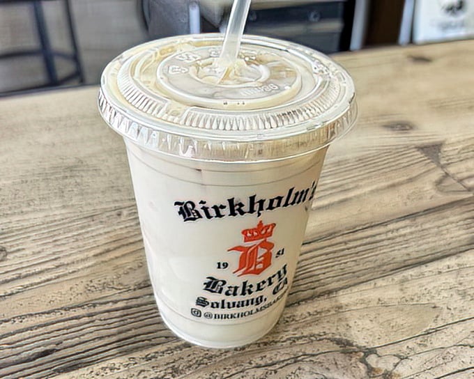 The branded cup isn't just holding a vanilla latte—it's containing liquid happiness that's been perfected since 1951, no passport required.