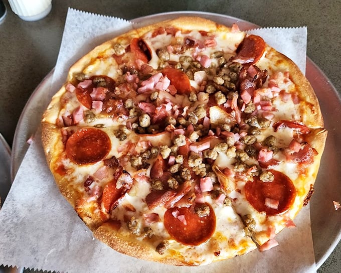 The meat lover's pizza doesn't just have toppings – it has a carnivorous congregation celebrating atop a perfect crust.