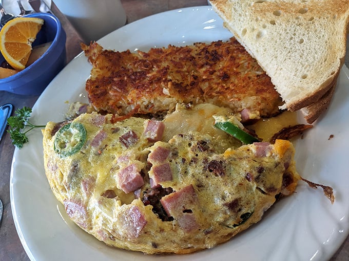 An omelet that's achieved that elusive perfect fold—stuffed with ham and veggies in a delicate egg embrace that's both hearty and refined.