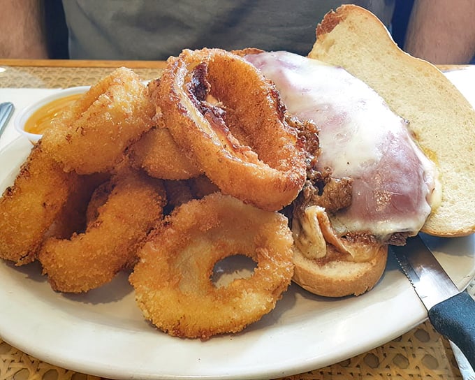 This sandwich with onion rings isn't just lunch—it's an engineering marvel where crunch meets melt in a symphony of textures.