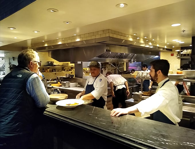 The open kitchen – where culinary magic happens without smoke and mirrors, just skilled hands transforming ocean treasures into edible art.