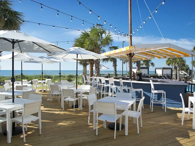 Al fresco dining with string lights and sea breezes. This outdoor deck captures the essence of coastal dining – casual elegance with your toes practically in the sand.