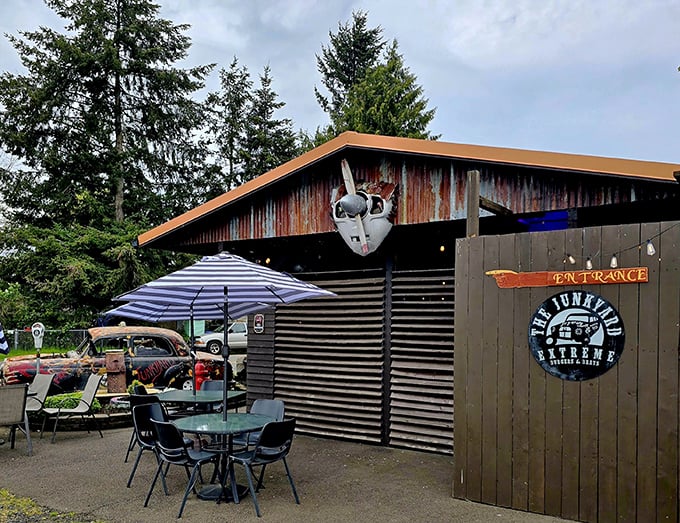 Outdoor seating with a side of actual junk—including what appears to be a partial car. Authenticity you can't manufacture, only accumulate. 