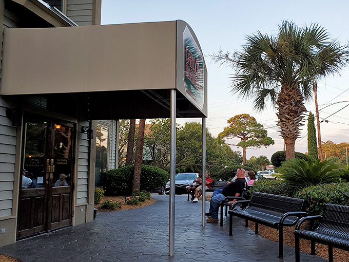 The outdoor waiting area isn't just practical—it's a palm-lined preview of the coastal comfort waiting just beyond those wooden doors.