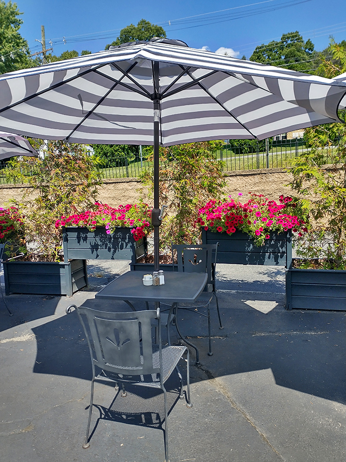Garden dining perfection—striped umbrellas and bright flowers create a breakfast oasis that makes even Monday mornings feel like mini-vacations.