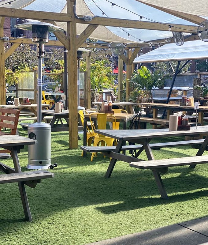 The outdoor seating area features picnic tables on artificial turf – because grass would never survive the stampede of hungry barbecue pilgrims.