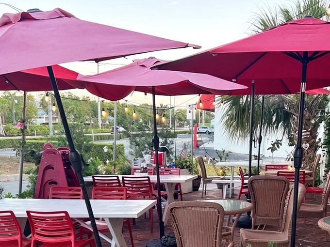 Pink umbrellas creating an outdoor oasis where Florida's perpetual sunshine becomes your dining companion instead of your nemesis.