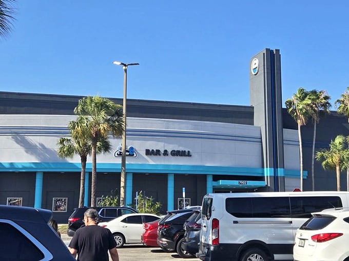 The parking lot basks in Florida sunshine, palm trees standing tall against the blue sky as visitors arrive for their indoor adventure.