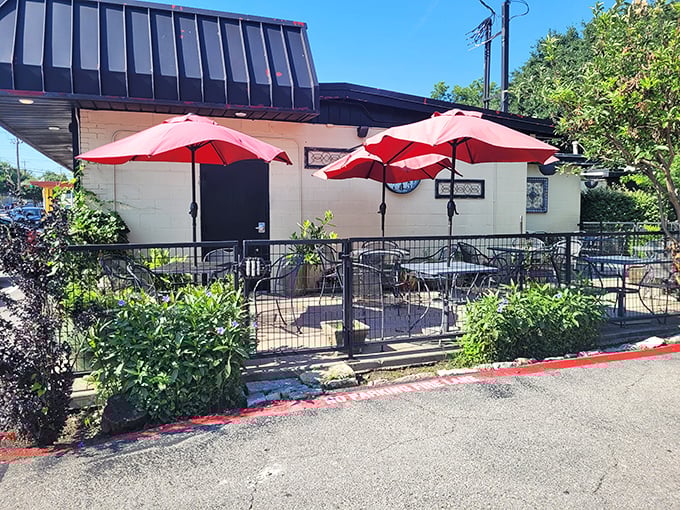 Red umbrellas shade the patio where Texans brave the heat for outdoor dining – dedication to breakfast knows no temperature limits.