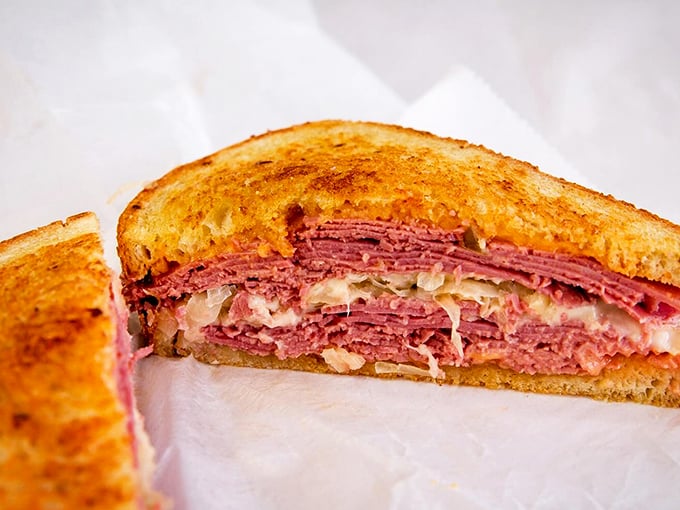 The Reuben reveals its layers like a delicious geological formation – corned beef, sauerkraut, and Russian dressing between grilled rye.