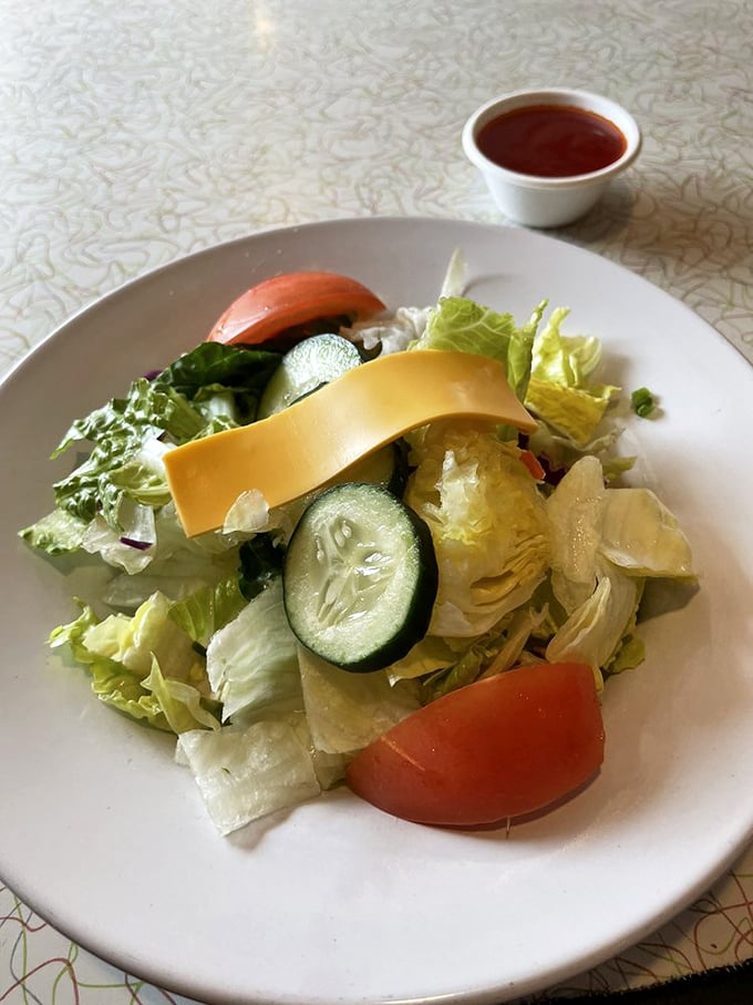 Even the salad looks honest – fresh ingredients without pretension, a nod to those who want greenery before their burger indulgence.