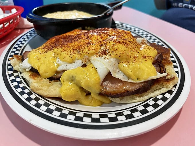 This isn't just breakfast—it's architecture. Eggs Benedict reimagined on a Southern biscuit with creamy grits standing by for emotional support.
