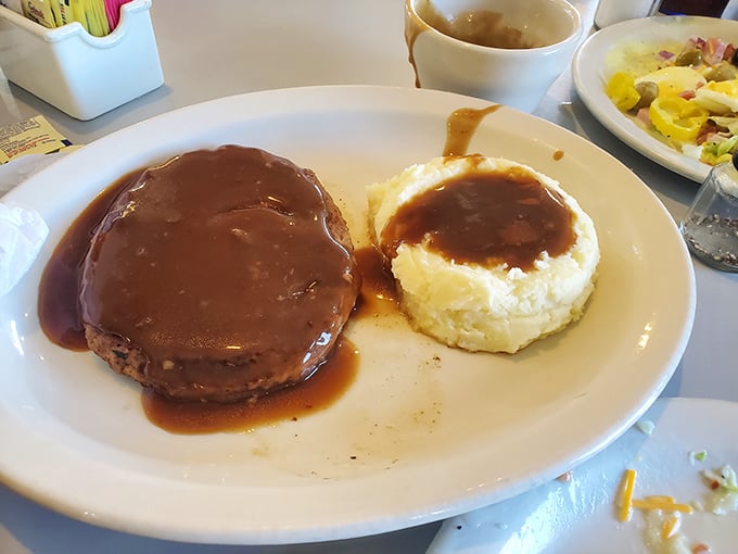 Salisbury steak swimming in gravy with mashed potatoes standing by—comfort food that hugs you from the inside out.