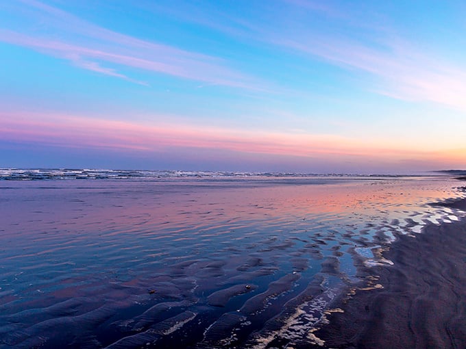 Low tide transforms the beach into a mirror for the sky's pastel performance—nature's way of doubling the beauty without charging extra admission.