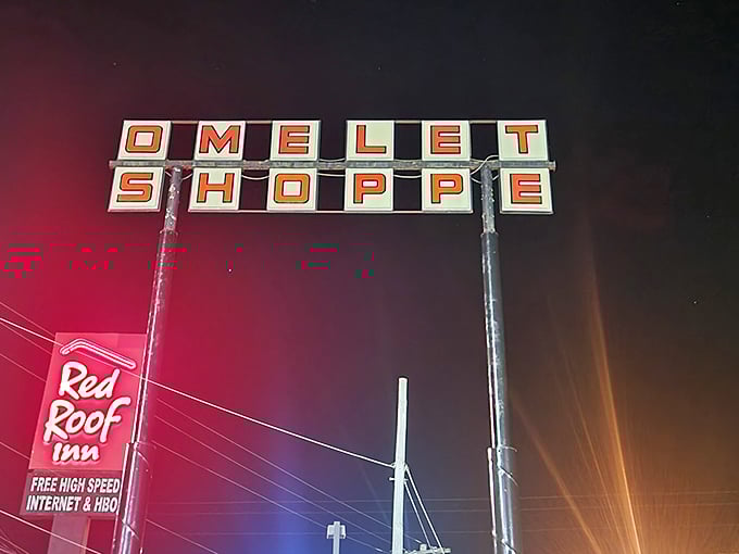 At night, the Omelet Shoppe sign transforms into a neon promise that tomorrow morning, eggs will be perfectly scrambled and coffee will be hot.