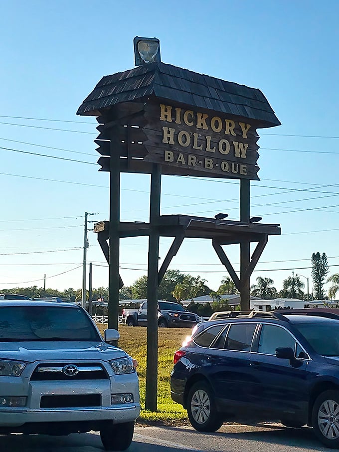 The Hickory Hollow sign against blue Florida skies—a landmark that's guided hungry travelers to barbecue bliss for generations.