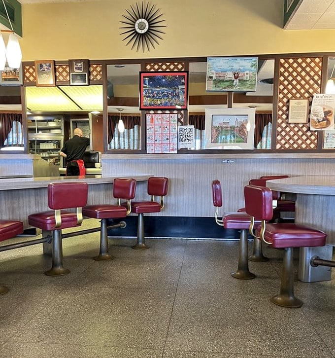 Where kitchen magic happens daily. Those red stools aren't just seating—they're front-row tickets to a performance of American diner classics.