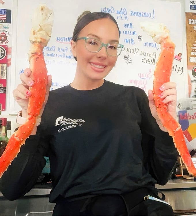 The staff proudly displays the star attraction—crab legs so impressive they deserve their own red carpet entrance.