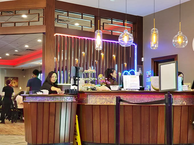Staff members orchestrate the dining experience from behind a counter that pulses with light—the command center of comfort food operations.