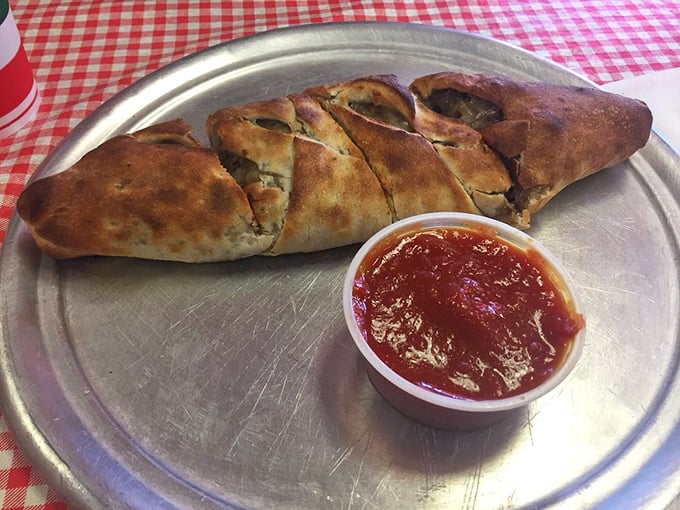 The stromboli—pizza's mysterious cousin who rolled itself up into a golden crescent of possibility, served with marinara for essential dipping adventures.