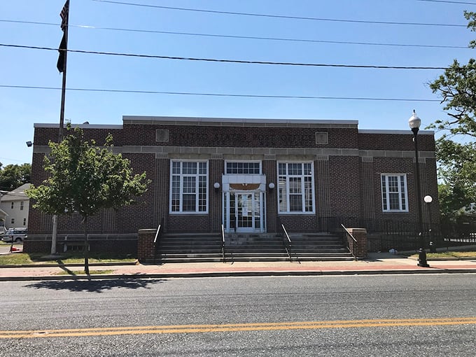 This stately brick building houses essential services in architectural dignity, representing the practical infrastructure that makes small-town living both pleasant and possible.