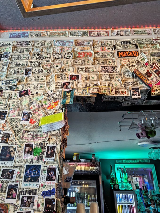 Dollar bills plastered across the wall like financial wallpaper, each one signed by someone who had a really good time here.