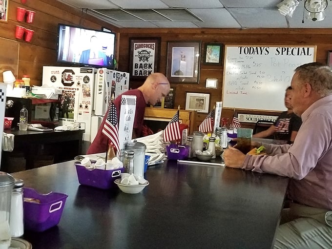 The counter where regulars perch like birds on a wire, sharing news and views while American flags stand proudly nearby.