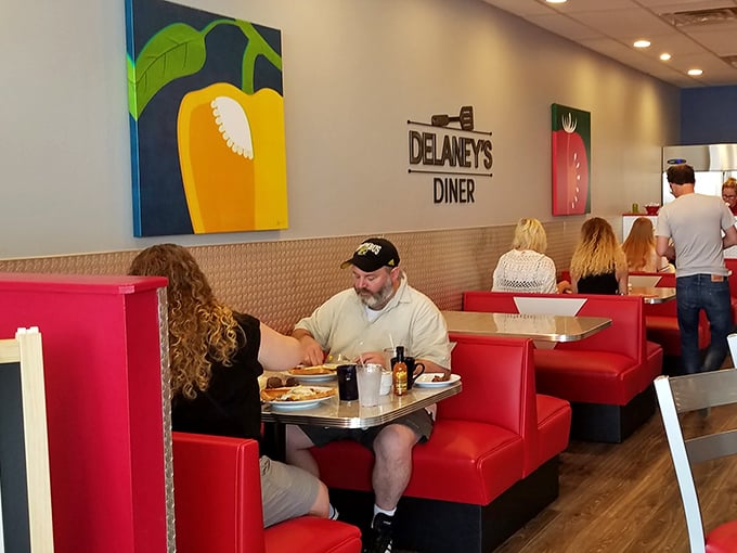 Those red booths aren't just seating—they're conversation incubators where strangers become friends over shared syrup bottles and coffee refills.