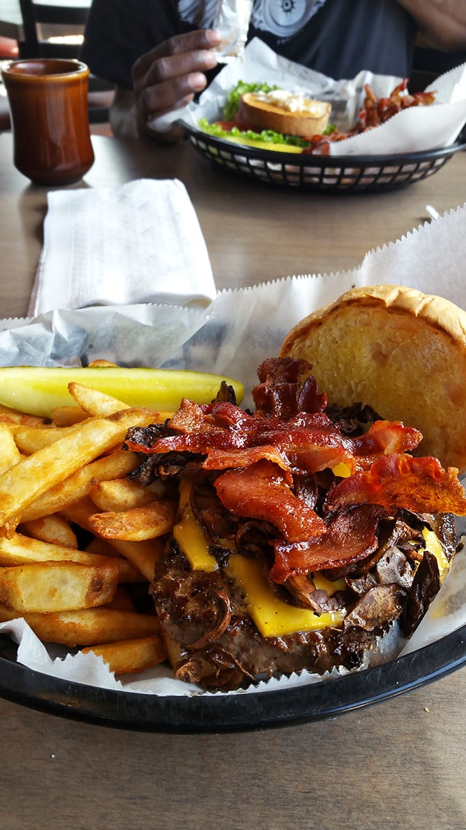 A burger that requires both hands and a strategy. Those fries aren't sides—they're essential companions on this flavor journey.