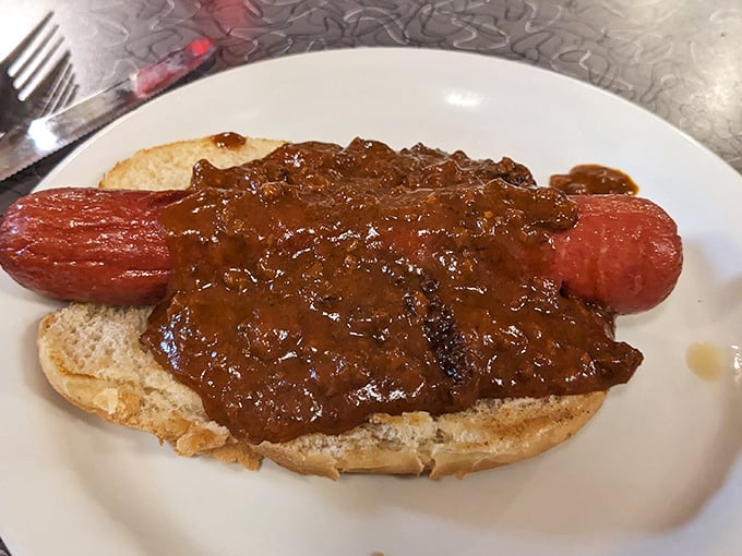 Chili dog decadence: Where a humble hot dog meets its destiny under a blanket of hearty chili – fork required, napkins essential.