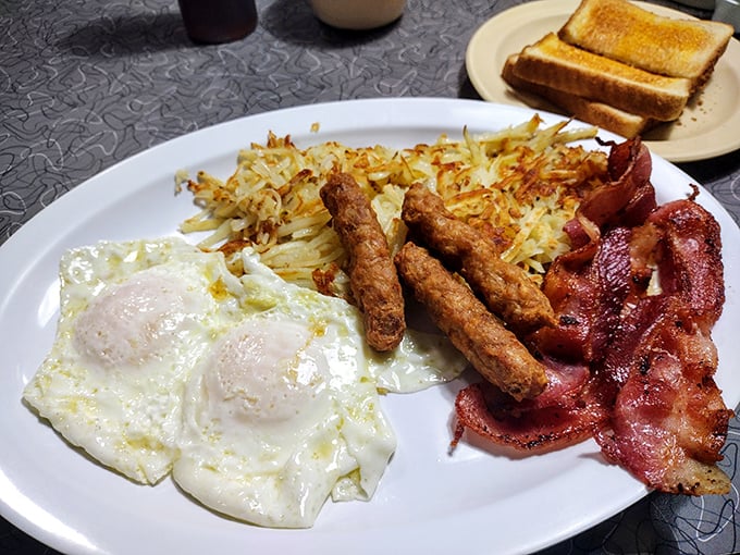 The breakfast trinity—eggs, bacon, and hash browns—performing in perfect harmony on a plate. Morning salvation has arrived.